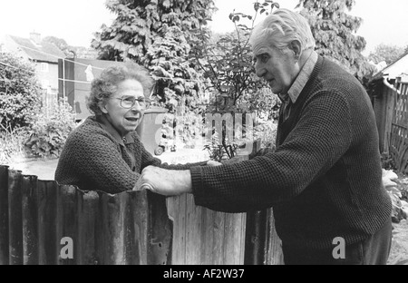 Neighbors talking over the fence Stock Photo - Alamy
