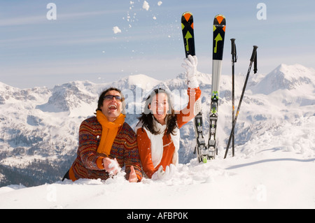 Winter activities. Couple throwing snow up in winter forest. People ...