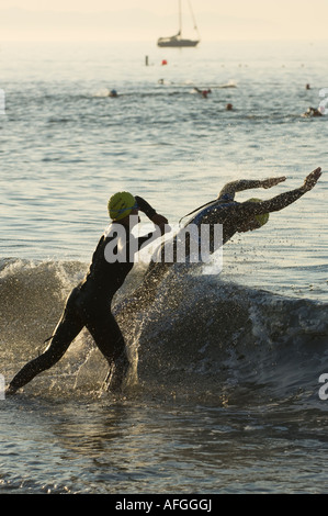 Swimmers dive over wave into cold Pacific ocean for swimming section of ...