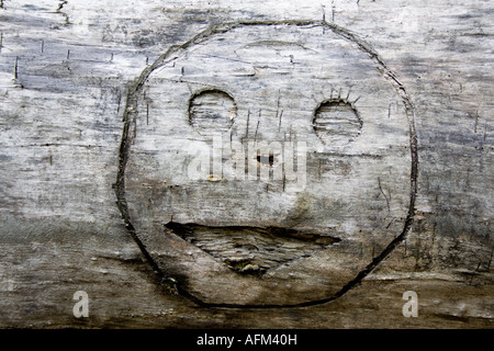 smile graven a long time ago in wood Stock Photo - Alamy