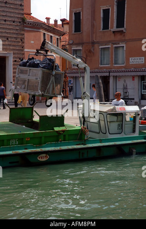 Venetian rubbish collection boat with crane emptying trash containers ...