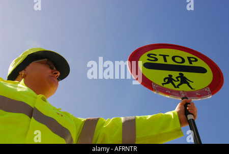School crossing patrol woman with stop sign and police officer on the ...