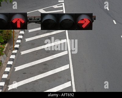 Traffic lights suspended above a road junction, blue sky background ...
