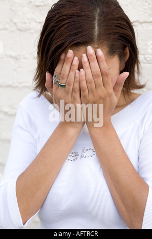 Modest and shy young woman hiding her naked body behind an oriental rug ...