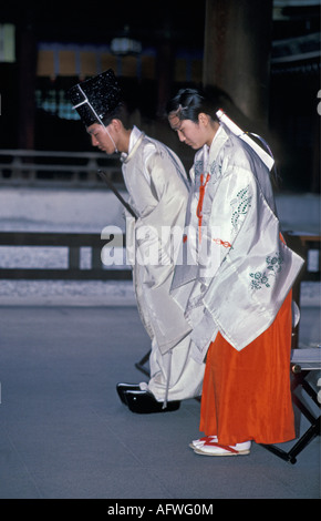 Japanese Shinto priest in traditional costume carrying a heavy bag down ...