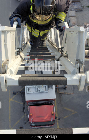 Fireman getting into firetruck Stock Photo - Alamy