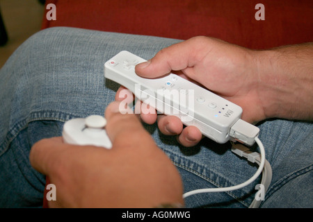 male hands holding Nintendo Wii remote control Stock Photo - Alamy