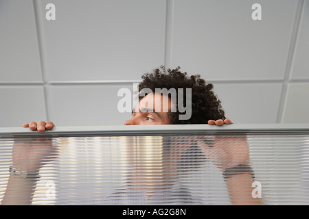 Office worker peering over cubicle wall Stock Photo - Alamy