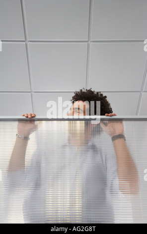 Man peeking over cubicle wall Stock Photo - Alamy