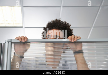Man peeking over cubicle wall Stock Photo - Alamy