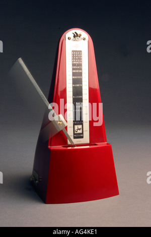 Red metronome with swinging pendulum Stock Photo - Alamy