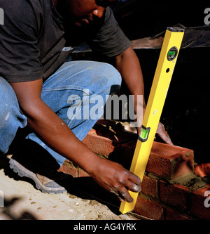 Mason checking the level of a wall, Bricklayer with personal protective ...