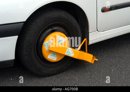 White car with DVLA wheel clamp and notice Stock Photo - Alamy