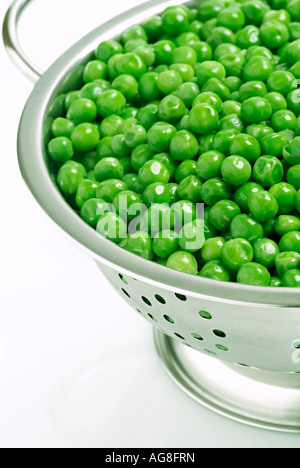 Close up of green peas in white ceramic bowl with red tomatoes blue ...