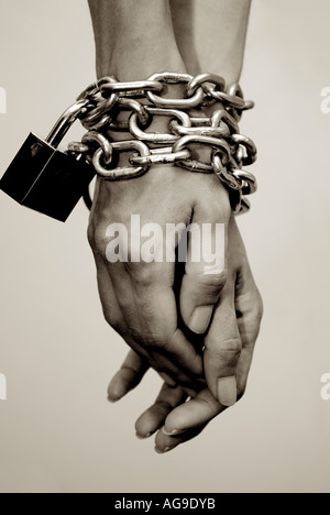 Female hands bound with chain and padlock. Isolated on a black ...