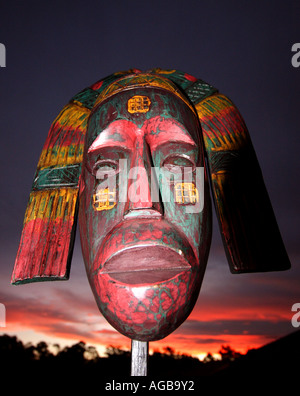 HAND CARVED WOODEN MASK AGAINST A RED SUNSET SKY HORIZONTAL BAPDB8174 ...
