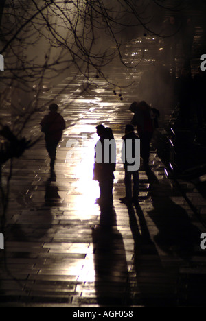 Moving people silhouettes on a wet night Stock Photo - Alamy