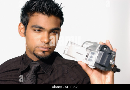 Young man using a video camera Stock Photo - Alamy