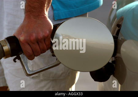 man hand refilling up gas tank of the car with green eco fuel on a ...