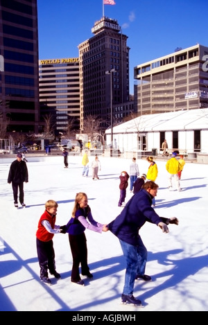 Father ice-skating with three children Stock Photo - Alamy