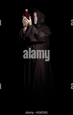 medieval alchemist holding flask with magic drink isolated on black ...