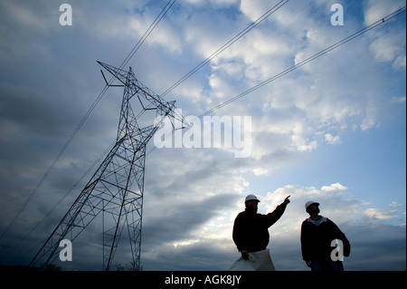 Workers building high voltage tower construction outdoors. Installation ...