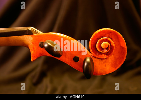 Side view of the scroll and pegs of a violin on a white background ...