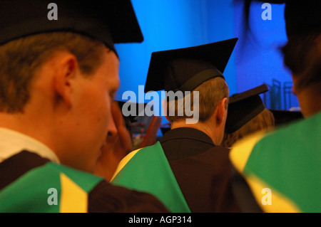 Young people in graduation gowns listen to a speech Stock Photo - Alamy