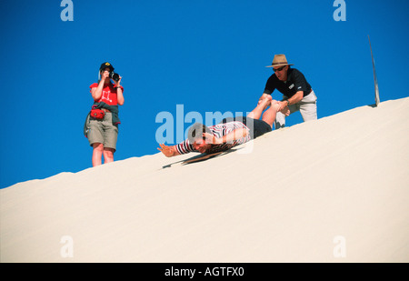 Man at sand tobogganing, Tangalooma Resort, Moreton Island, Queensland ...