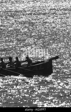 Trainera silhouetted by sun off Puerto Viejo de Algorta Basque Country ...