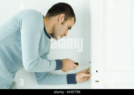 Man removing lock from door Stock Photo - Alamy