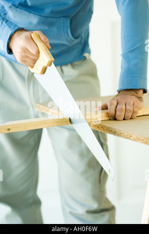 Man sawing wood, cropped view of hand Stock Photo - Alamy