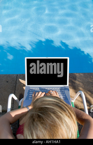 Workaholic lady working on holiday by the pool Stock Photo - Alamy