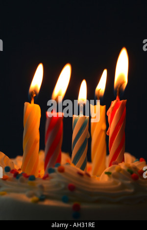 Colorful birthday light candles in a chocolate cake red background ...