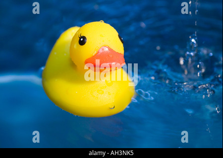 yellow plastic toy ducks falling down a waterfall and into the surge on ...