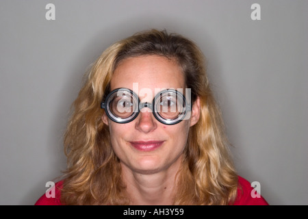 Yong blond woman wearing toy glasses with thick lenses Model Released ...