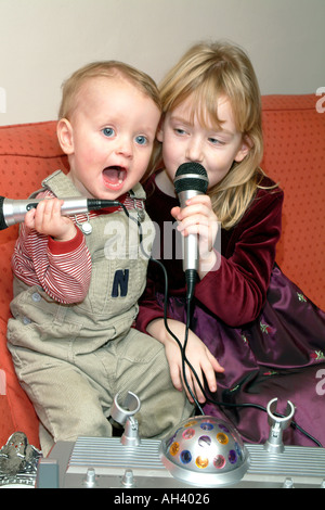 Brother and sister singing karaoke Stock Photo - Alamy