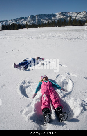 Two children making snow angels Stock Photo - Alamy