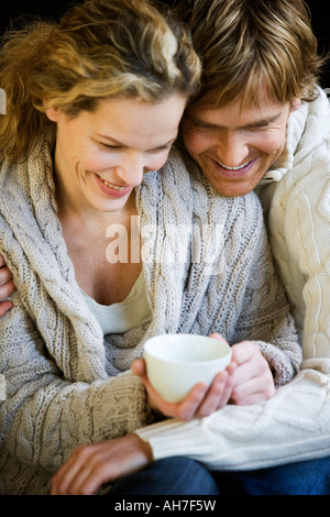 Woman holding a coffee cup smiling and looking away on a sunny day ...