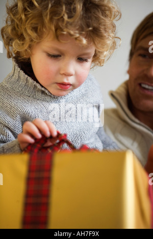 Boy and his father opening a Christmas present Stock Photo - Alamy