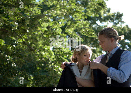 Woman putting her arm around the shoulders of a man, using a compass ...