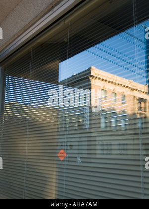 Vertical wide blinds outside the window in the light of the sunset, a ...