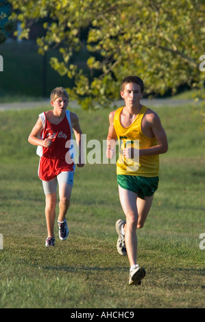 High school cross country runners running through a path in the woods ...