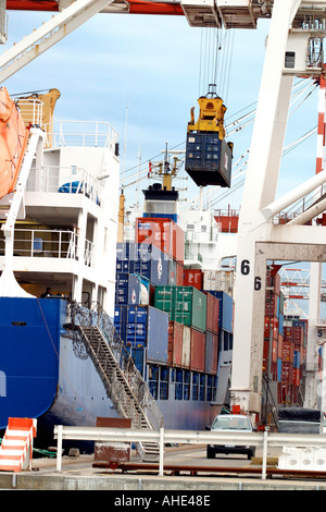 Crane charging container in cargo ship Stock Photo - Alamy