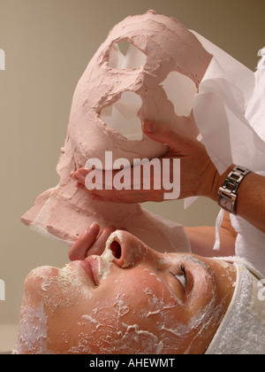 Beautician taking off facial mask from client face Stock Photo - Alamy
