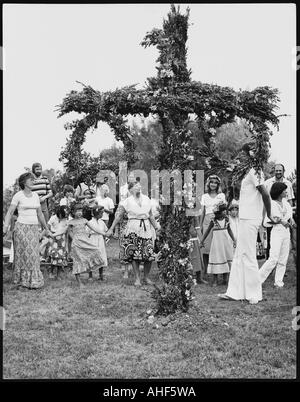 A Scandinavian Midsummer festival, centred around a large cross with ...