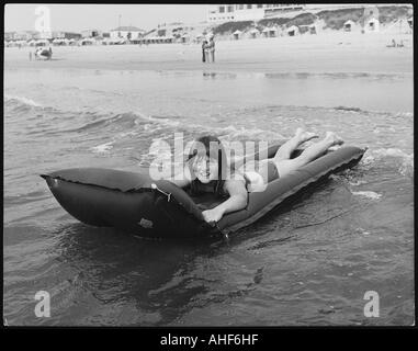 A happy girl on an inflatable lilo in what looks like rather cold sea ...