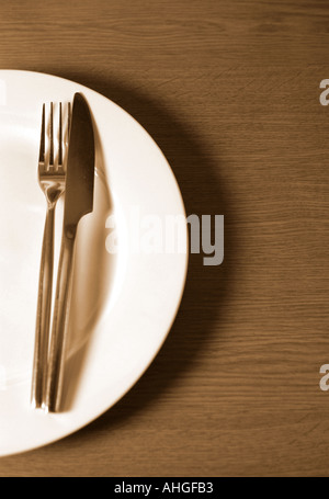 empty plate fork knife on concrete background Stock Photo - Alamy