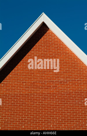 Gable end of a new-build home with scaffolding visible. Against blue ...