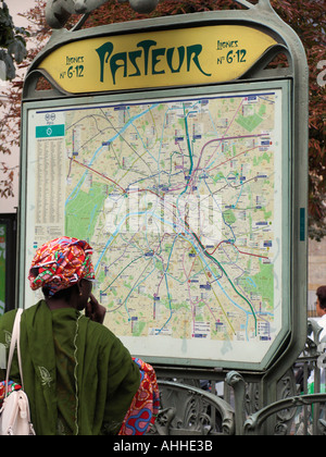 Woman studies subway map at Metro entrance Edgar Quinet Paris France ...